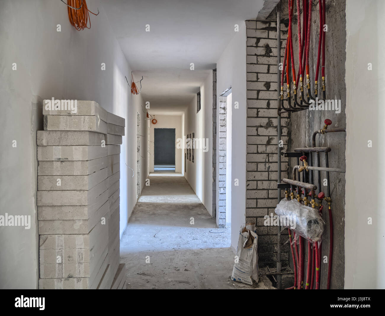 empty hallway inside building under construction with cables on the ...
