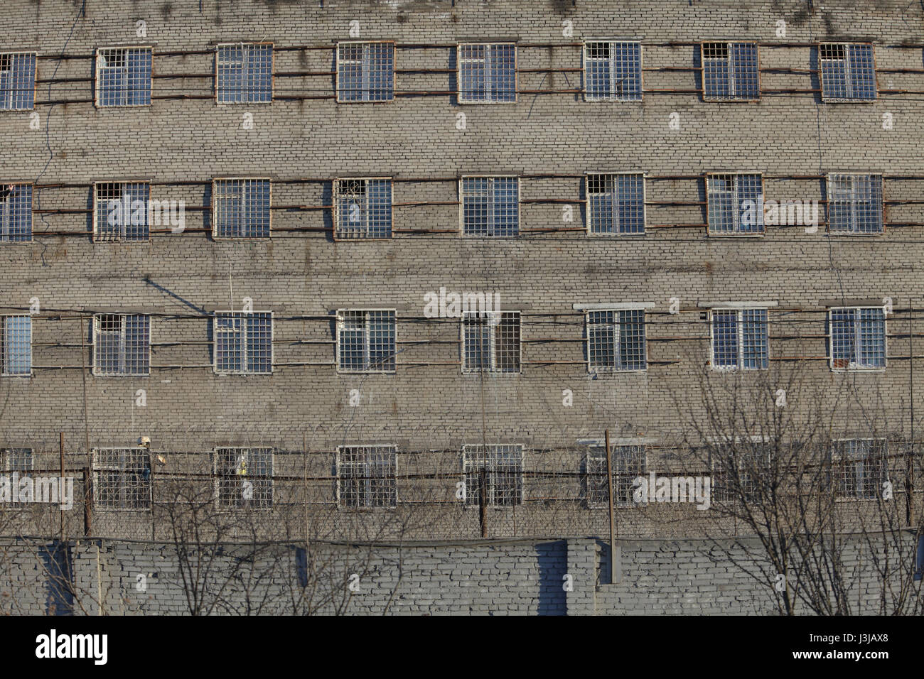 Wall of prison building with barred windows Stock Photo - Alamy