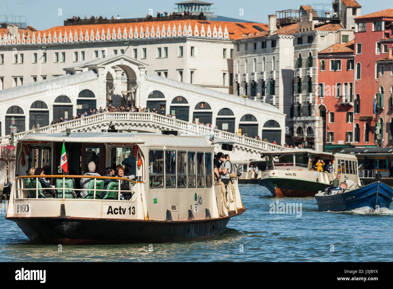 Vaporetto (water bus) on Grand Canal in Venice. Rialto bridge in the ...