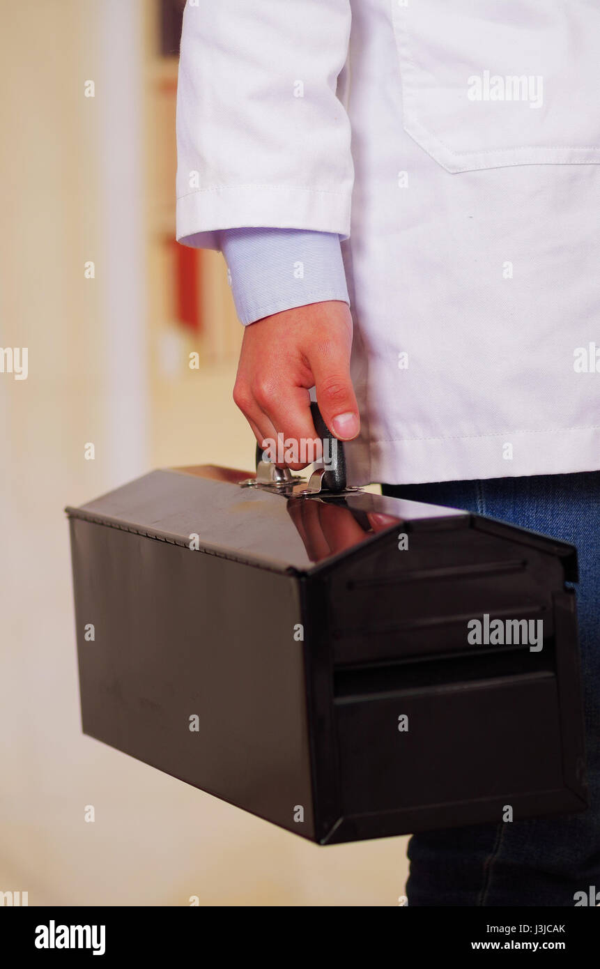 Hardworking Man holding a black tool box Stock Photo - Alamy