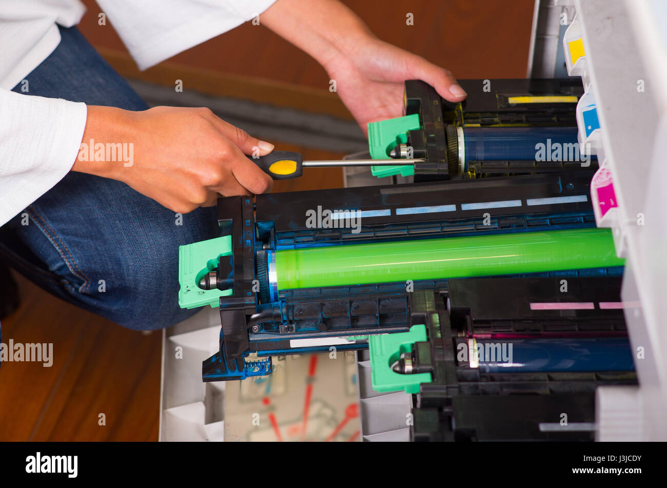 woman fixing a photocopier and smiling during maintenance using a ...