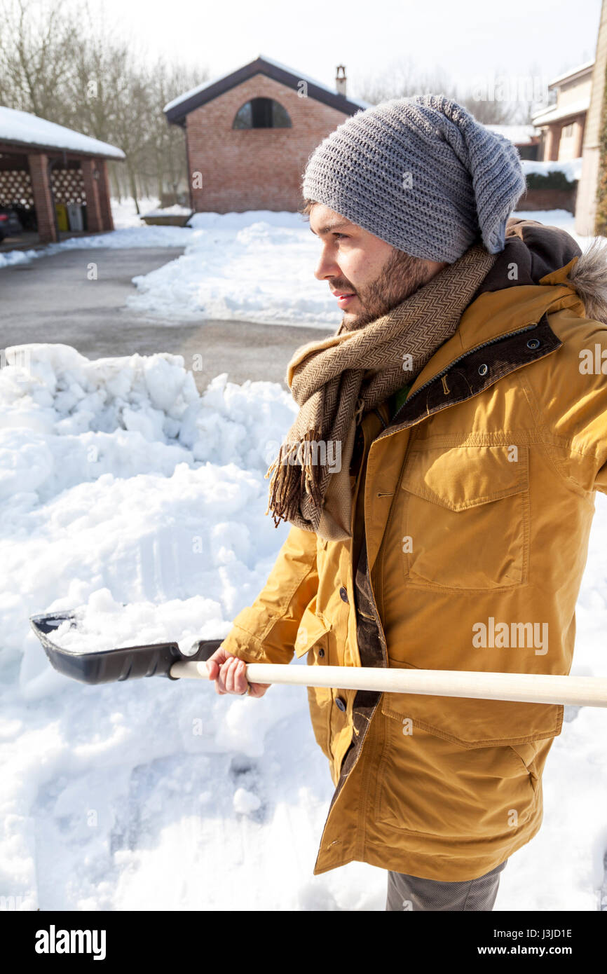young man shoveling snow near a farm Stock Photo - Alamy