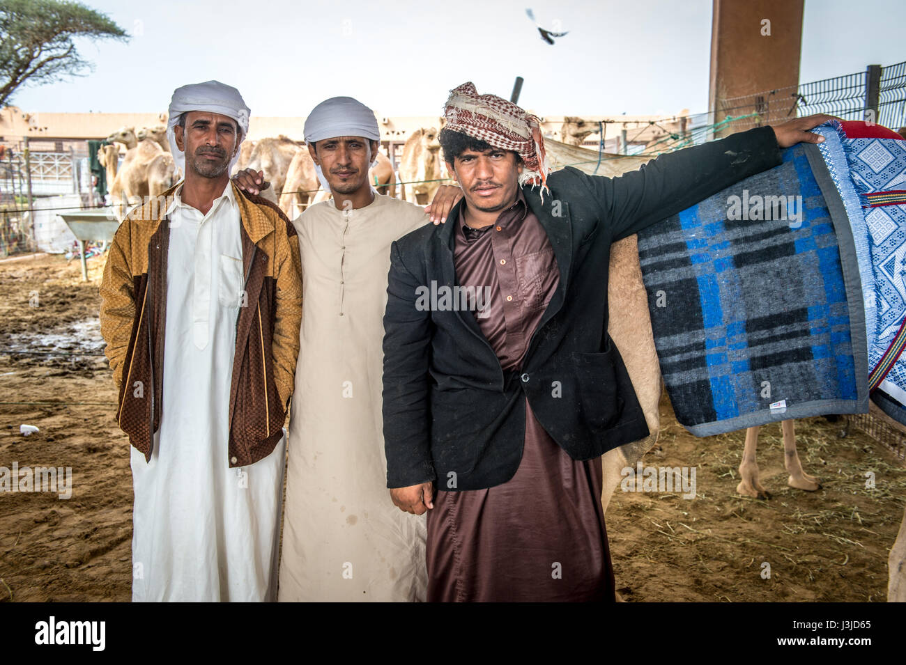 Camel traders pose for a photo with a camel at the Al Ain Camel Market ...