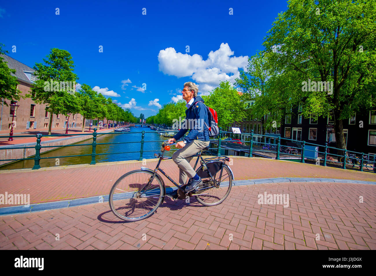 Amsterdam, Netherlands - July 10, 2015: Typical Dutch man bicycling ...