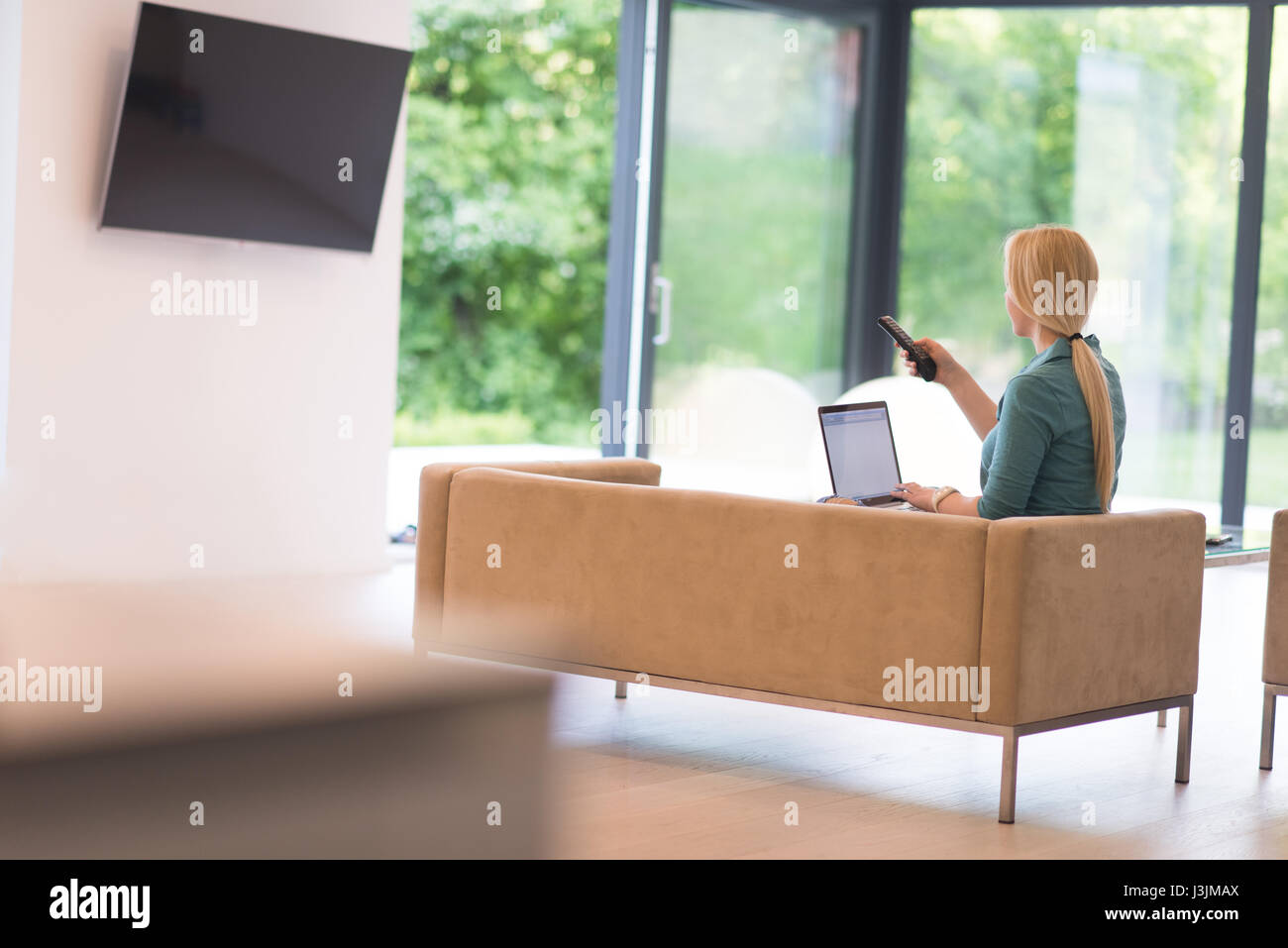Young woman using her laptop computer in her luxury modern home ...