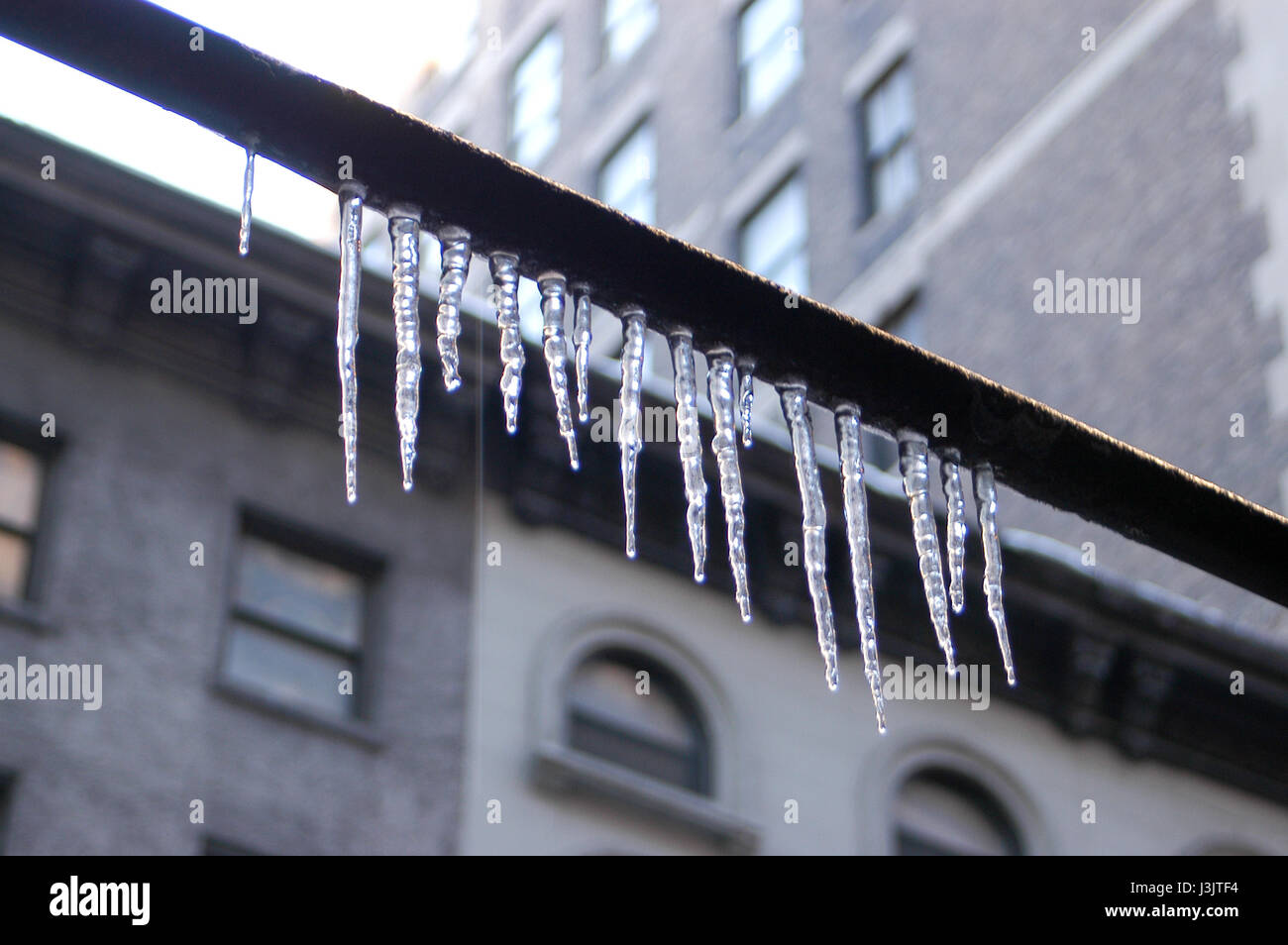 Icicles formed on a pole with the backdrop of New York City urban ...