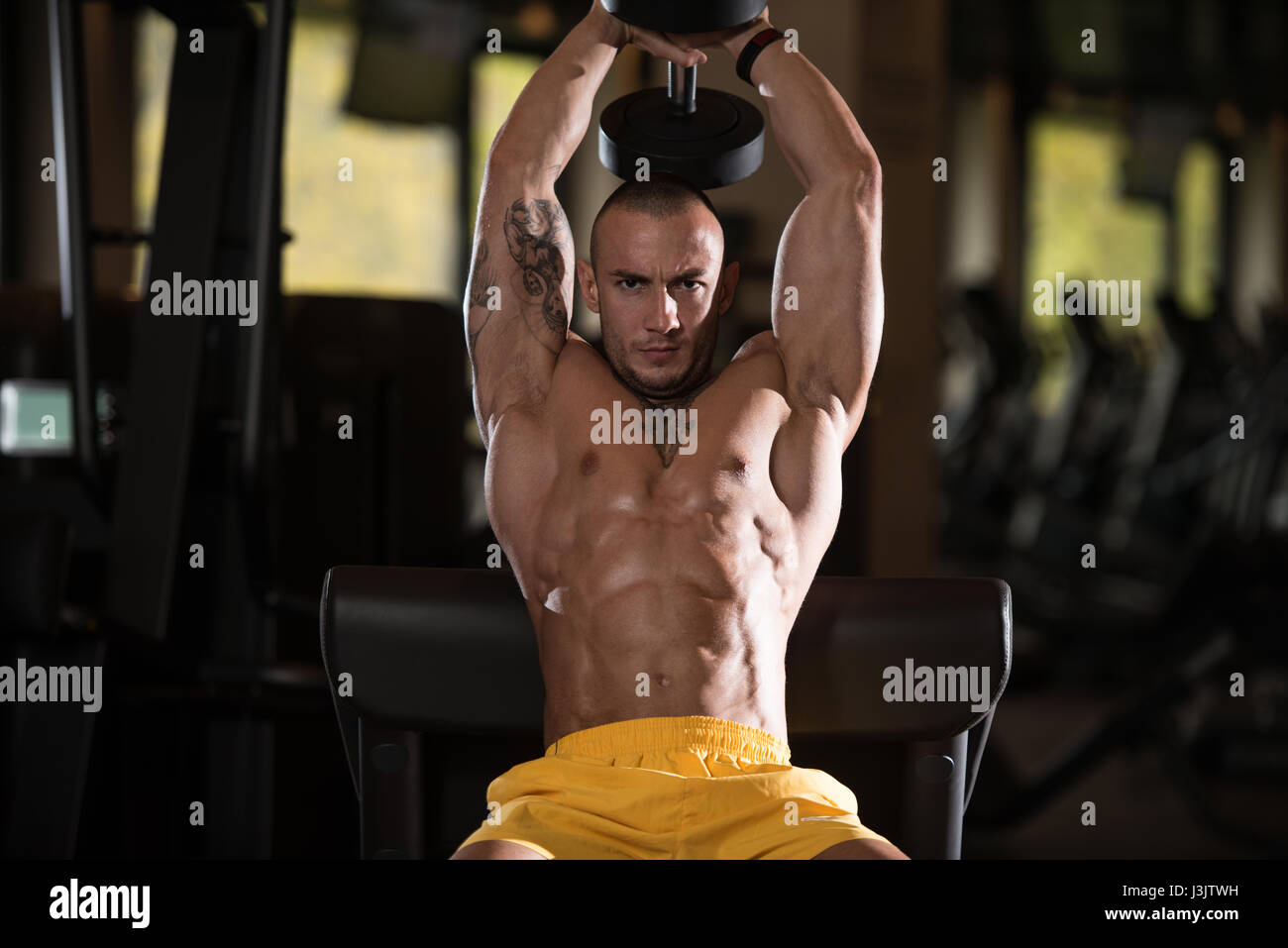 Athlete Working Out Triceps In A Gym With Dumbbell Stock Photo - Alamy