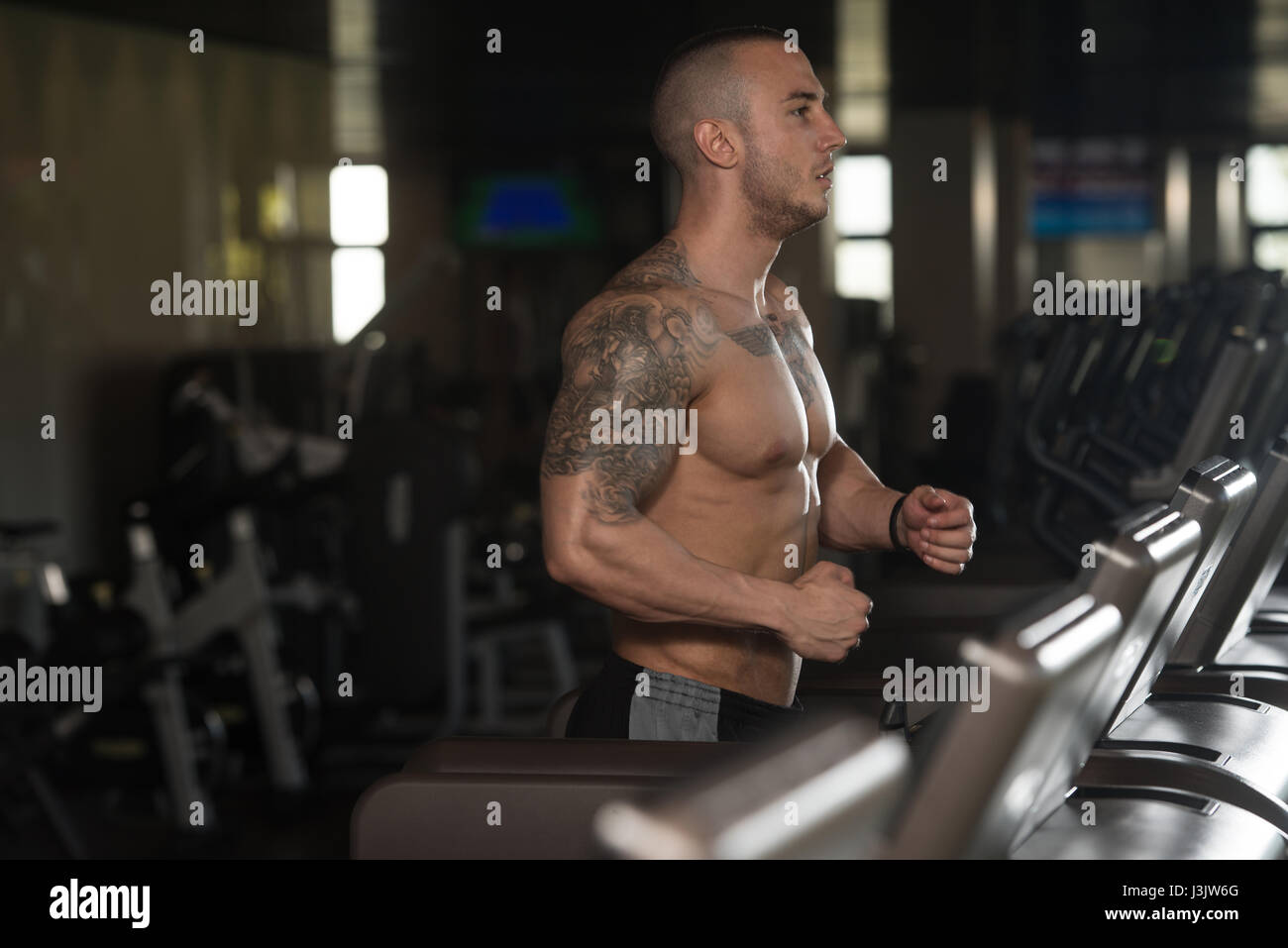 Handsome Man Running On The Treadmill In Gym Stock Photo - Alamy