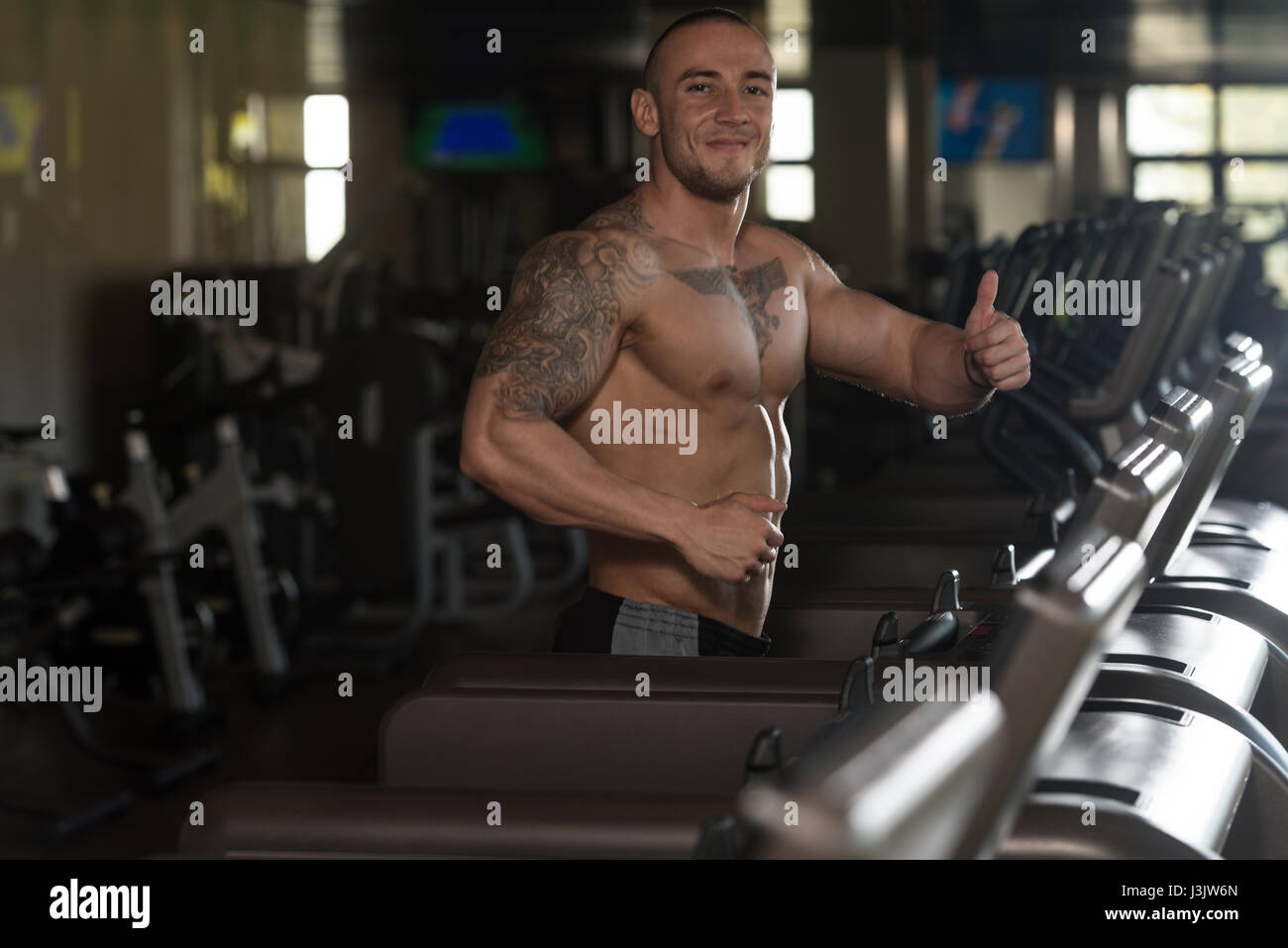Handsome Man Running On The Treadmill In Gym Stock Photo - Alamy