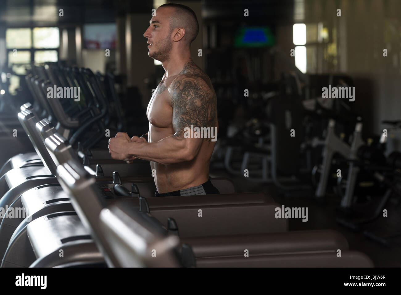 Handsome Man Running On The Treadmill In Gym Stock Photo - Alamy