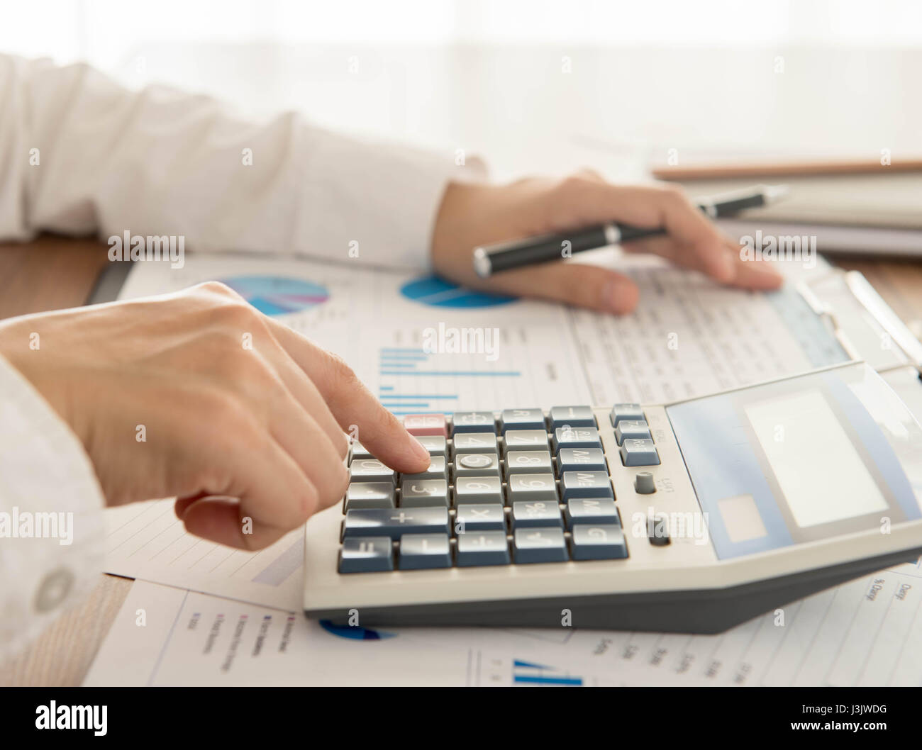 Businessman using a calculator to calculate the numbers Stock Photo - Alamy