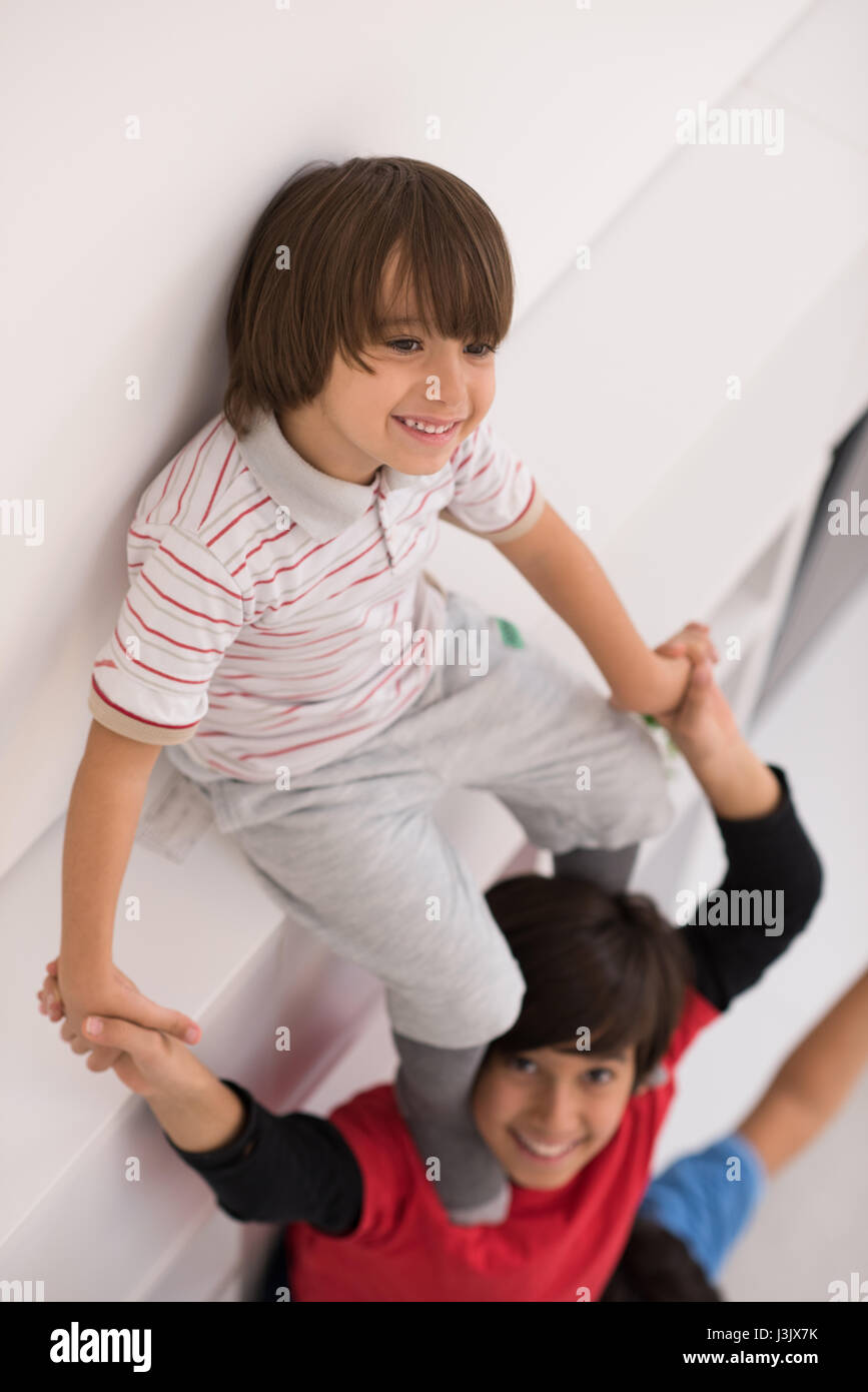 happy young boys having fun and posing line up piggyback in new modern ...