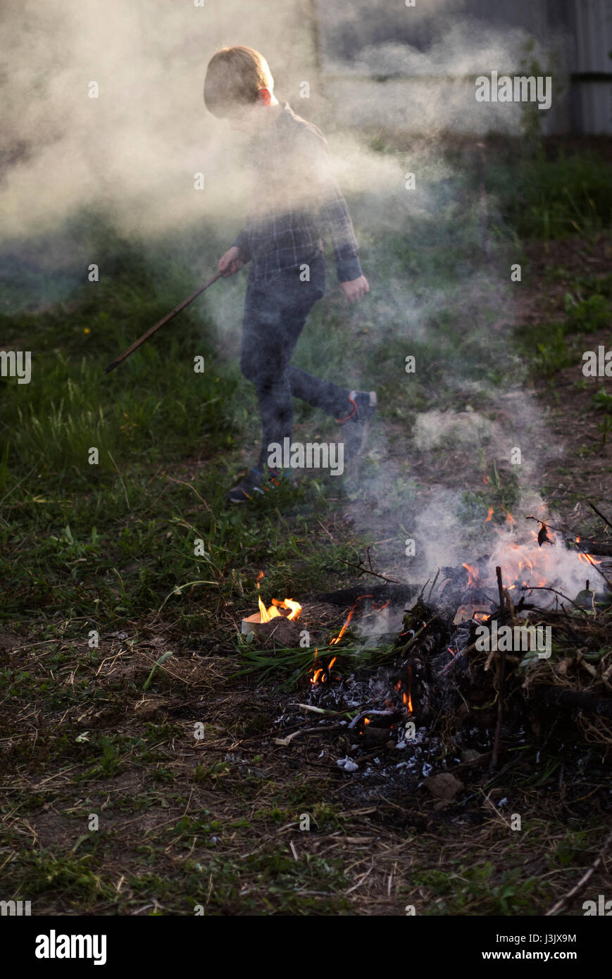 Boy making bonfire at the backyard Stock Photo - Alamy