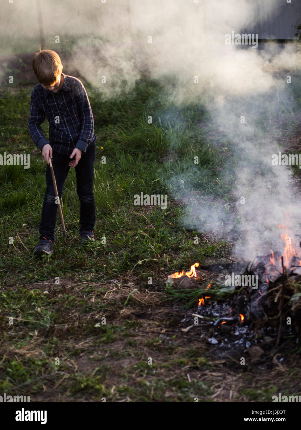 Boy making bonfire at the backyard Stock Photo - Alamy