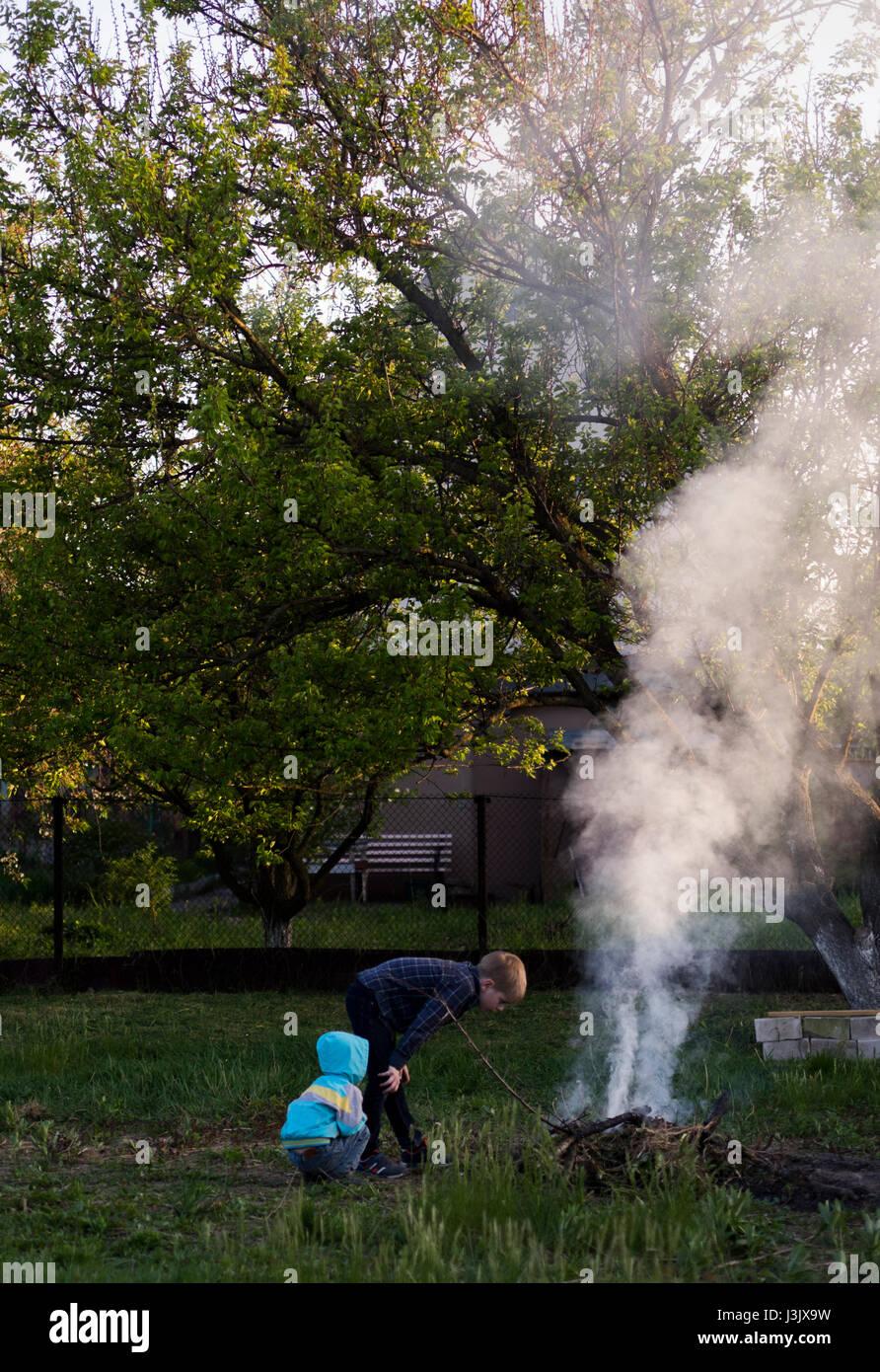Boys making bonfire at the backyard Stock Photo - Alamy