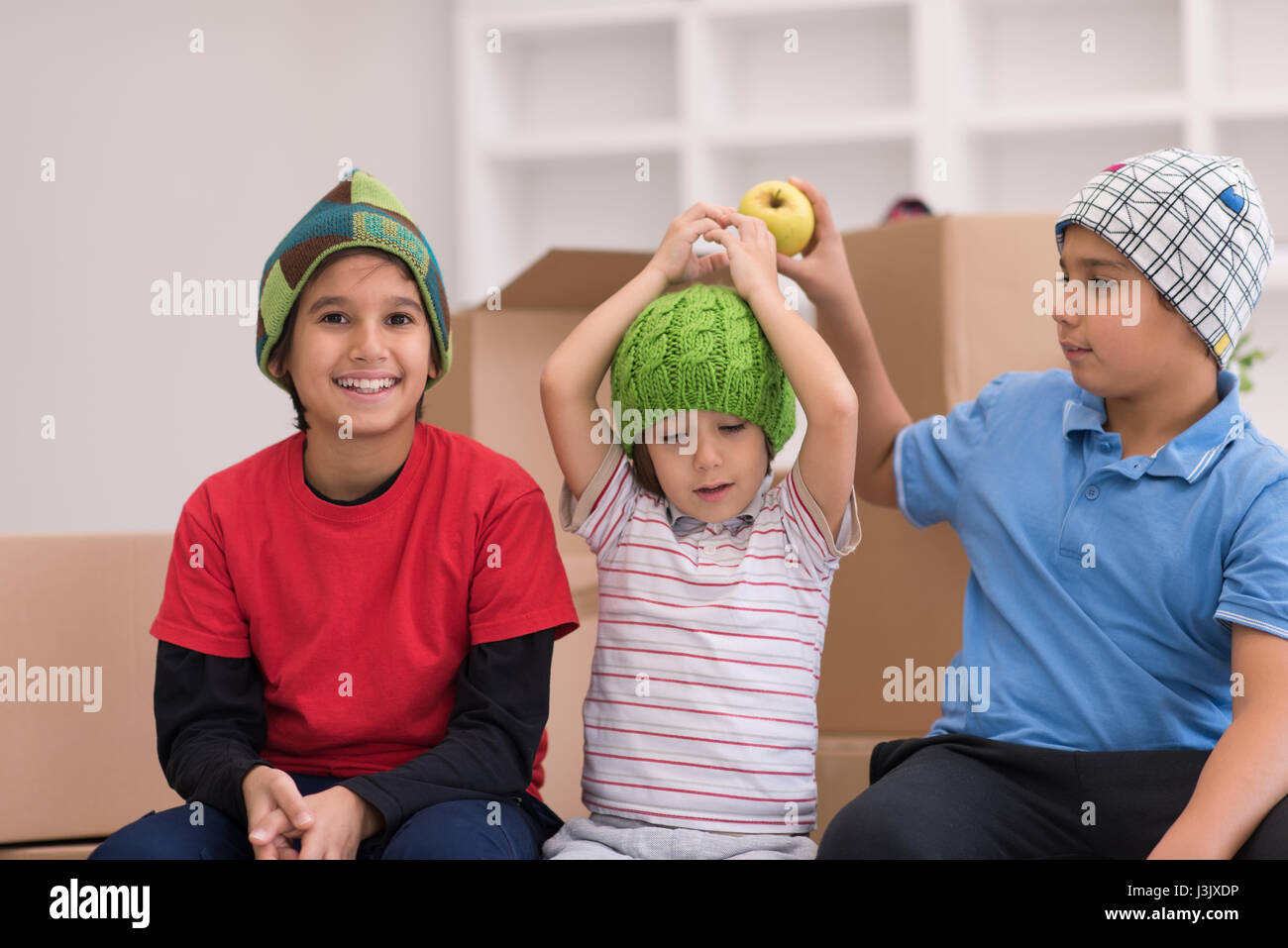 portrait of happy young boys with cardboard boxes around them in a new ...