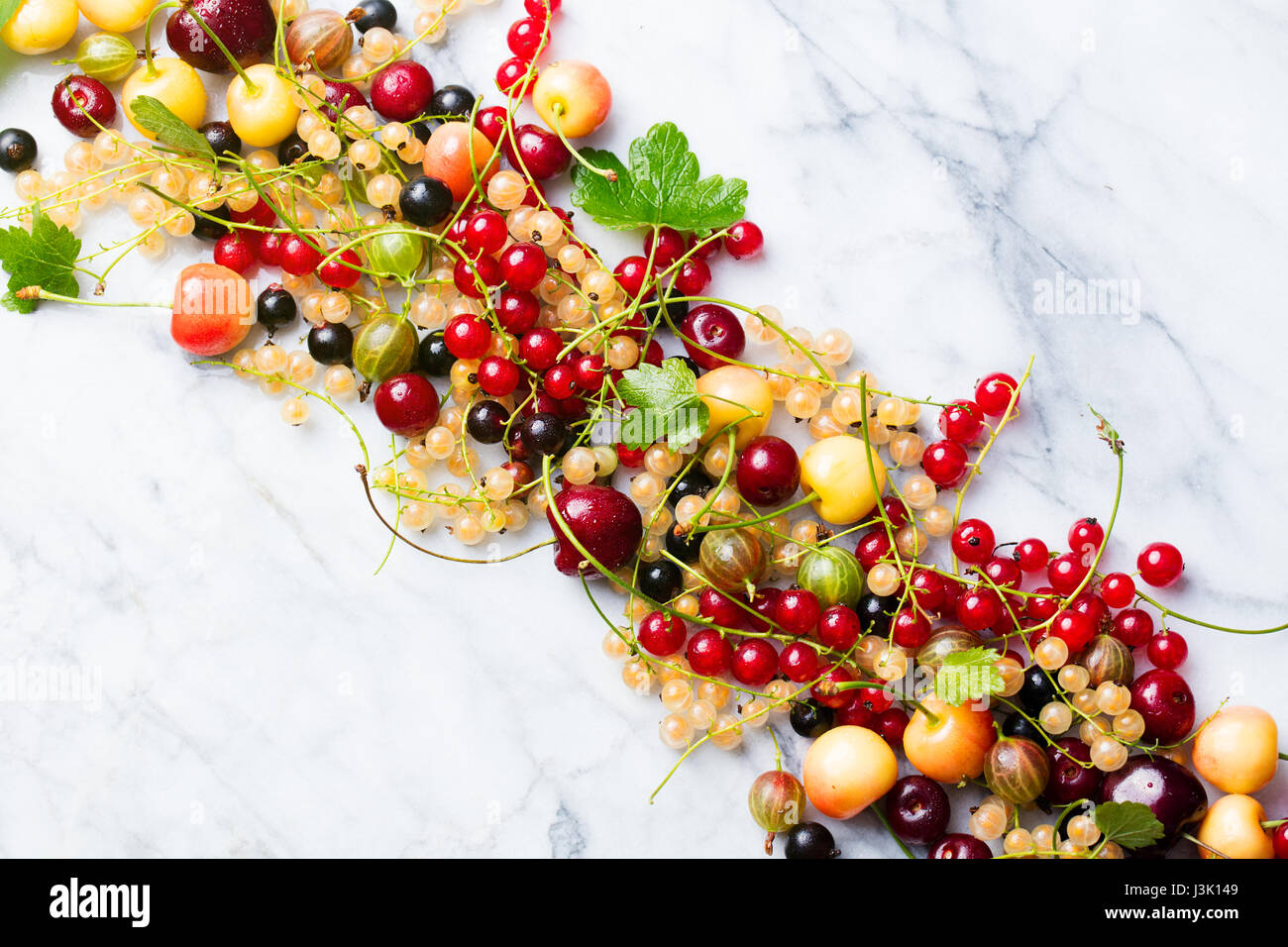 Assortment of fresh berries on marble background. Top view. Copy space ...