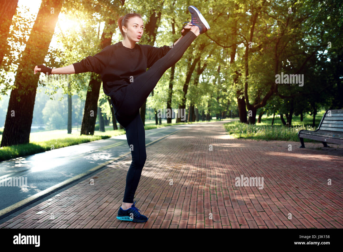 Young beautiful and strong woman actively doing physical exercises in a ...