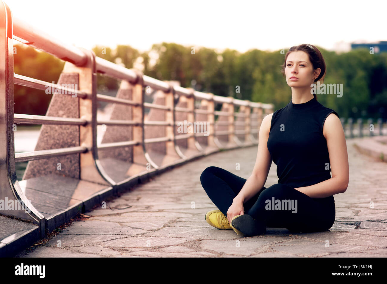 Young beautiful strong slender woman doing sports in summer park and ...