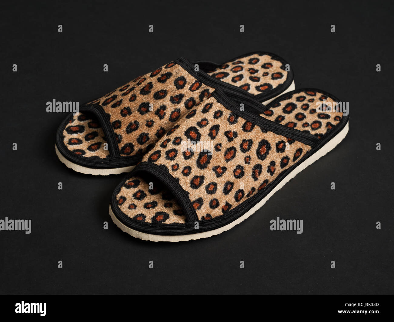Pair of slippers on black background Stock Photo - Alamy