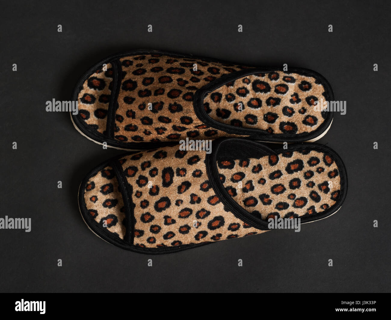 Pair of slippers on black background Stock Photo - Alamy