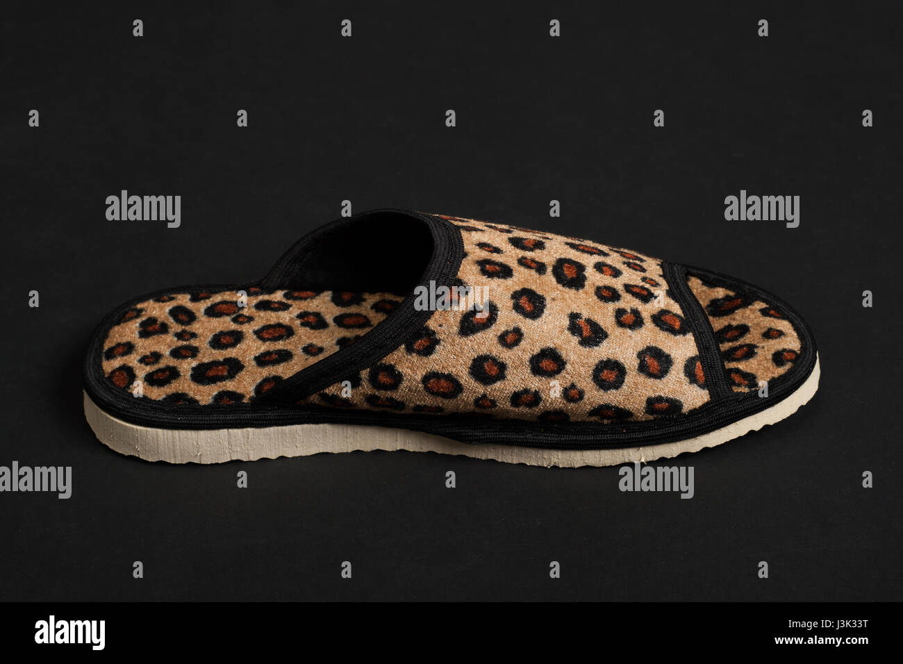 Single slipper on black background Stock Photo - Alamy