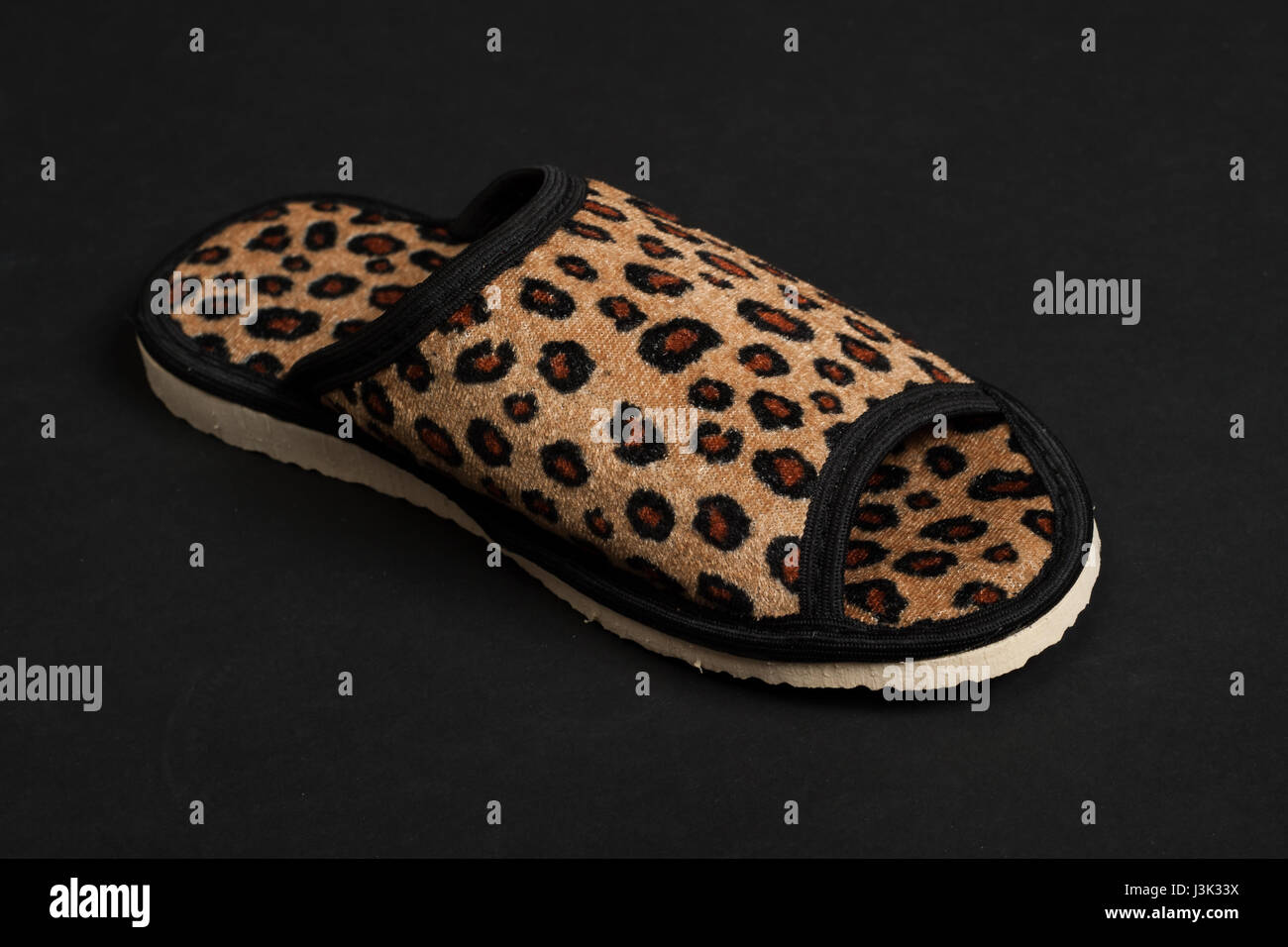 Single slipper on black background Stock Photo - Alamy