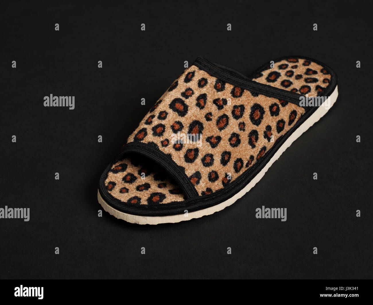 Single slipper on black background Stock Photo - Alamy