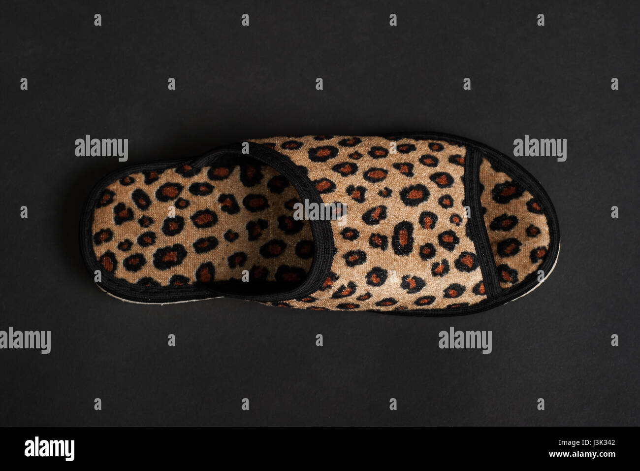 Single slipper on black background Stock Photo - Alamy