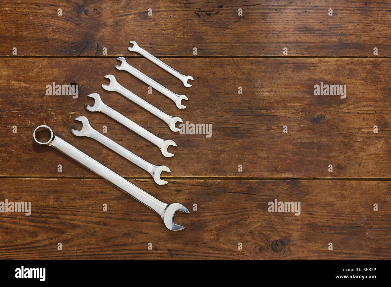 Neatly arranged spanner set on wooden boards Stock Photo - Alamy
