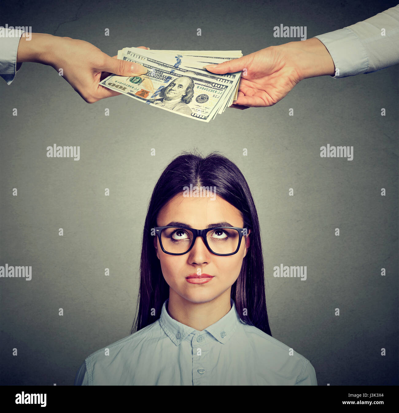 Worried sad woman looking up at two hands exchanging money Stock Photo ...