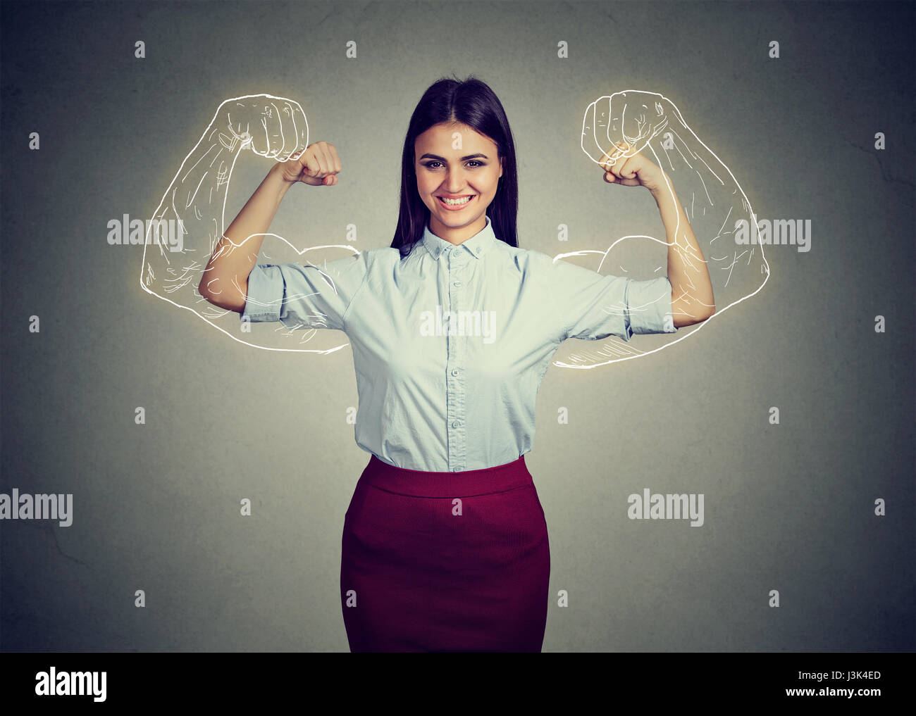 Powerful confident woman flexing her muscles isolated on gray wall ...