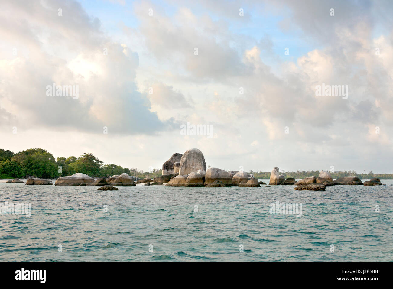 Natural granite rock formation placed in the ocean next to white sand ...