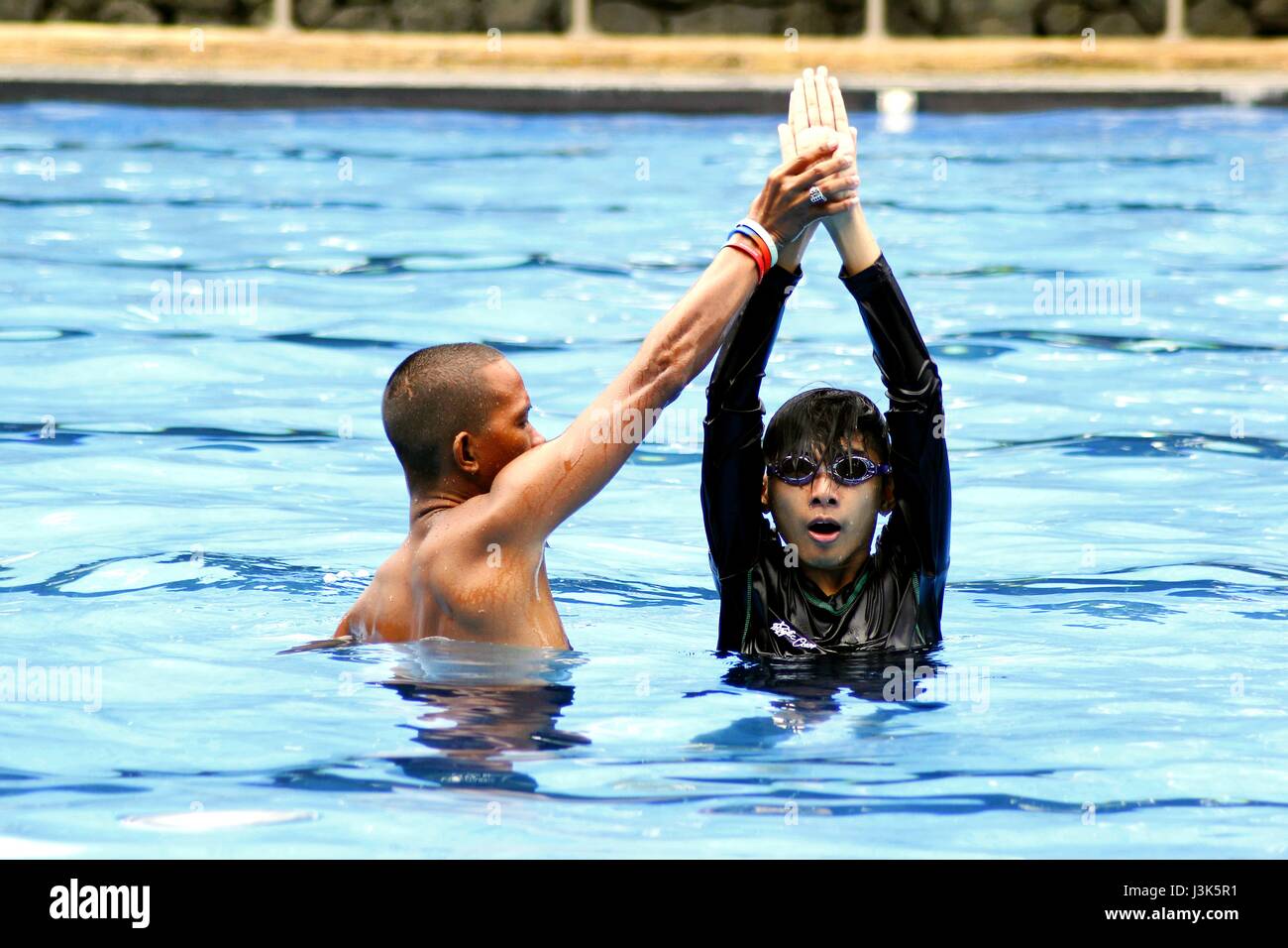 ANTIPOLO CITY PHILIPPINES MAY 5 2017 A Swimming Coach Teaches A Teenager Some Swimming antipolo-city-philippines-may-5-2017-a-swimming-coach-teaches-a-teenager-some-swimming
