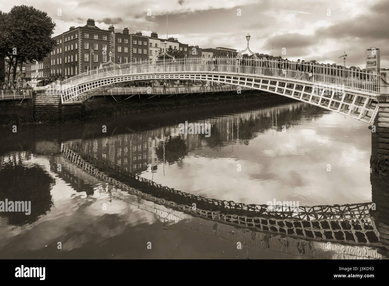 The Ha'penny Bridge, officially known as the Liffey Bridge, over a calm ...