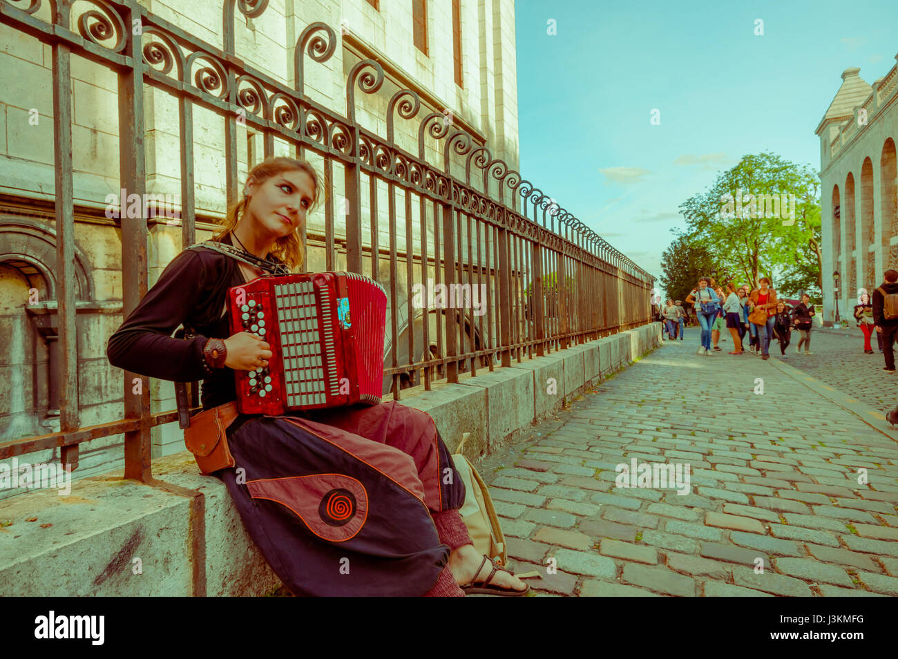 Paris, France June 1, 2015: Young gypsy woman sitting on concrete wall ...
