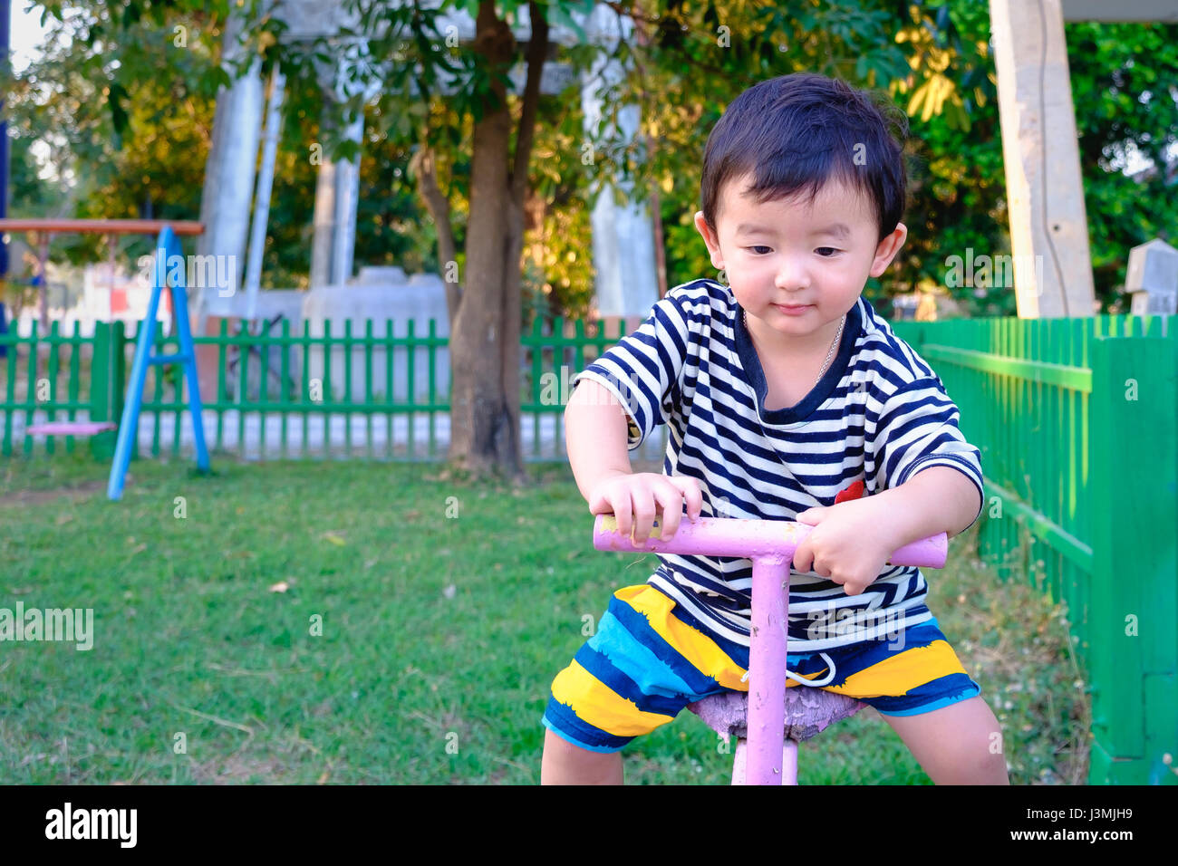 Happy kid play teeter-totter in kindergarten or preschool. shallow ...