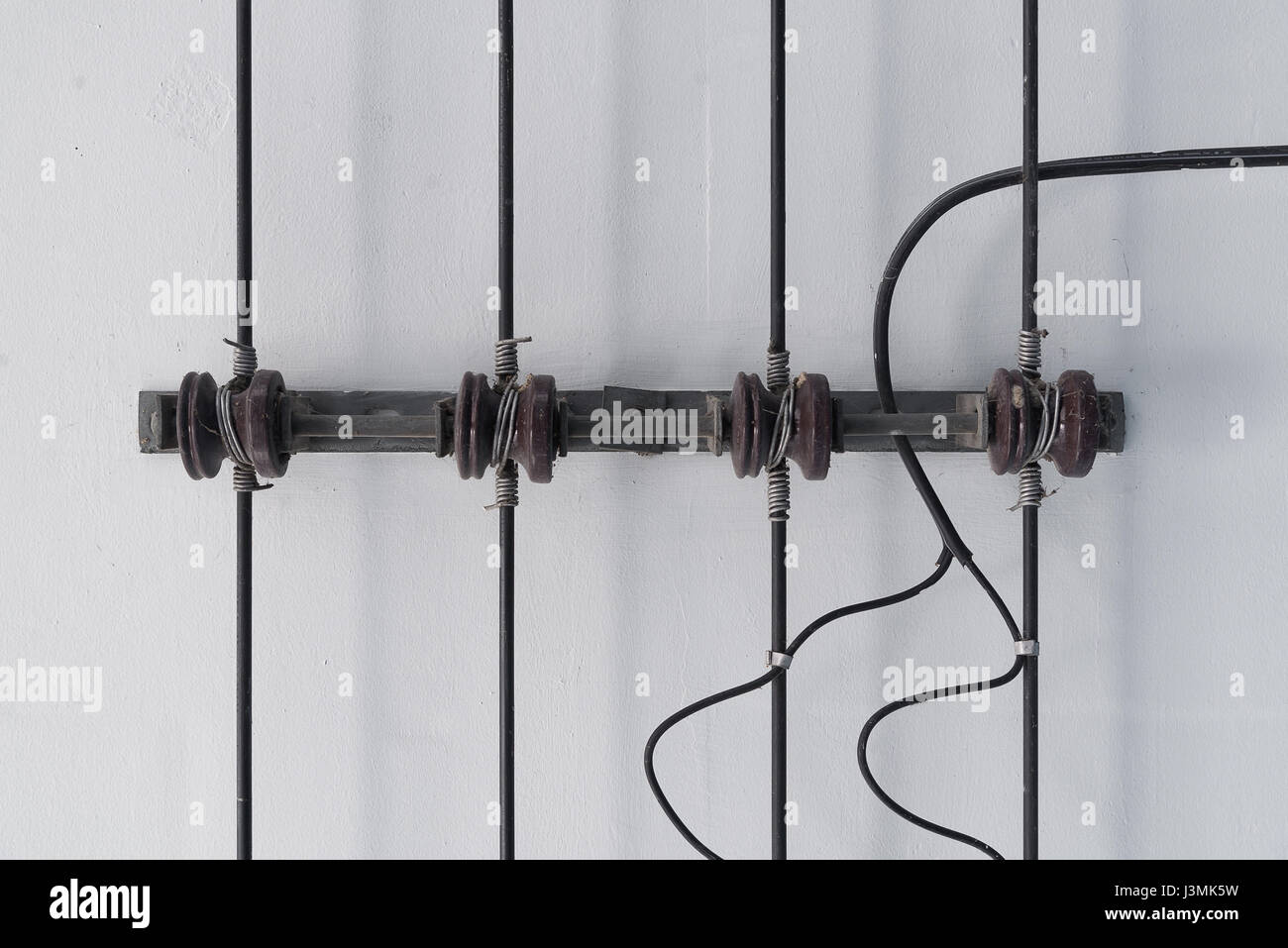 Power line and porcelain insulators with rack on white ceiling Stock ...