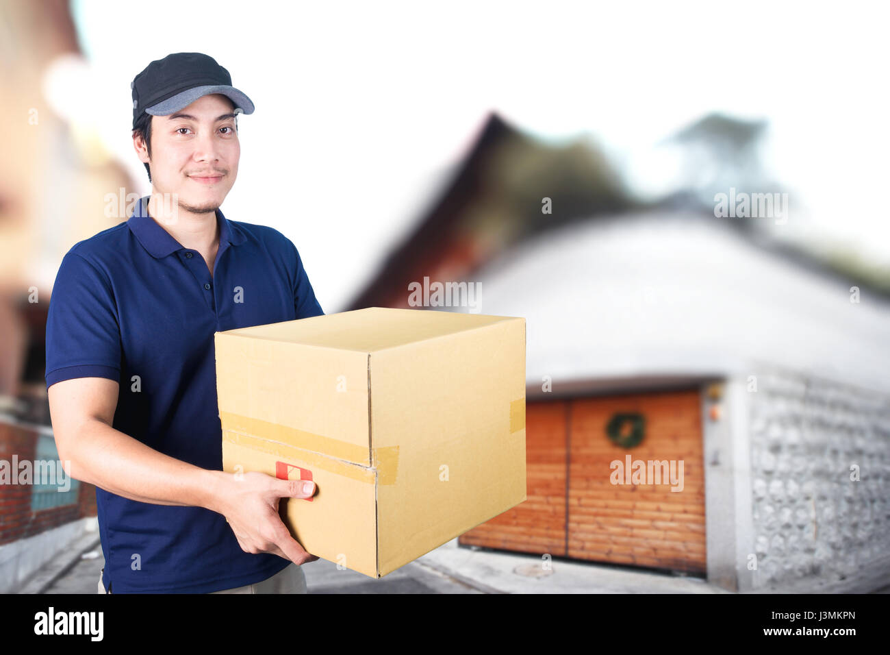Asian smile Delivery man with cardboard box in hand standing on blurred ...
