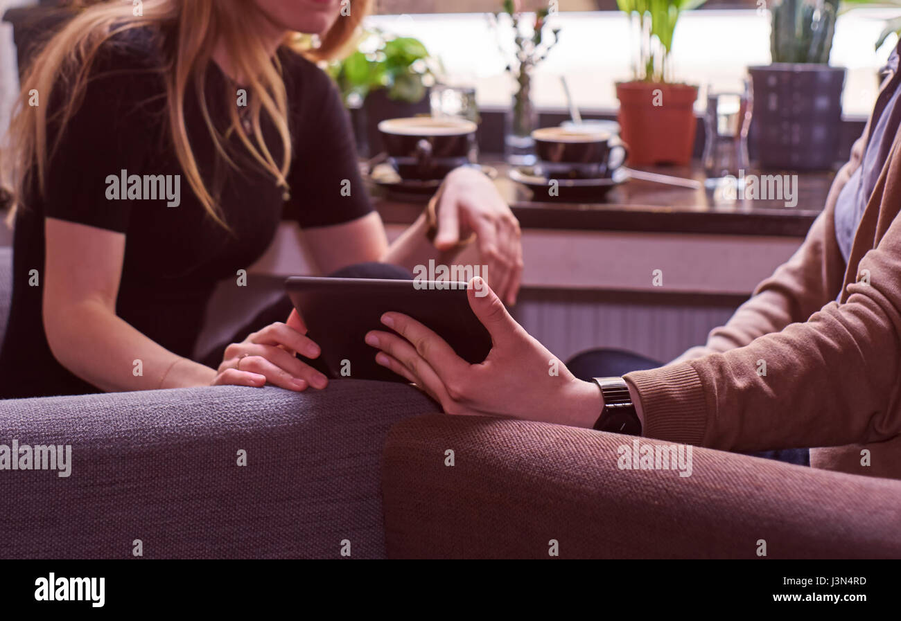 Crop shot of two young people using tablet in cafe Stock Photo - Alamy