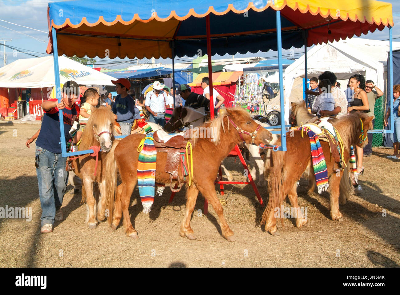 Valladolid, Mexico - 25 January 2009: childs riding ponys of a carousel ...