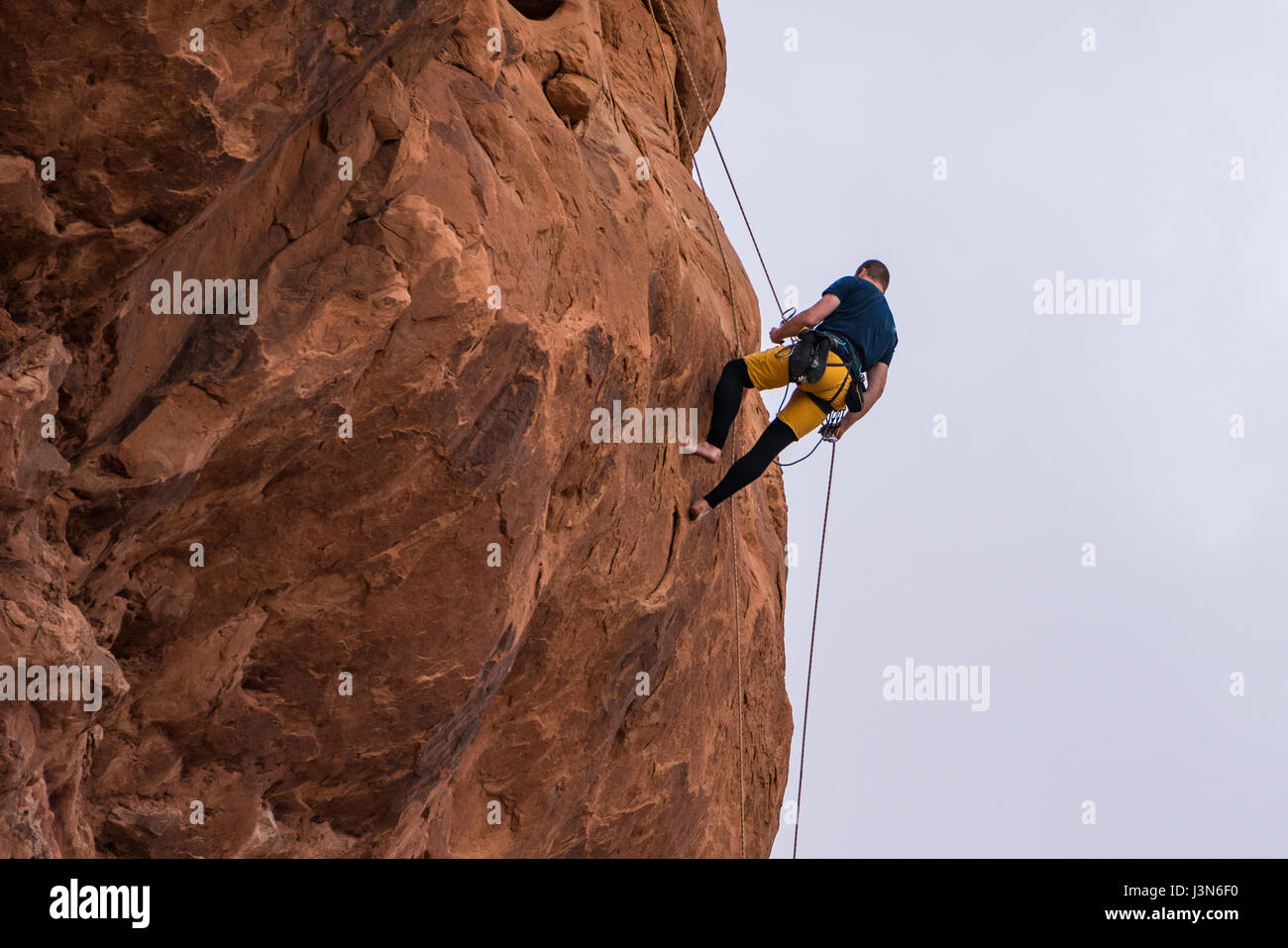 Rock climber descending pinnacle in Arches National Park, Utah Stock ...