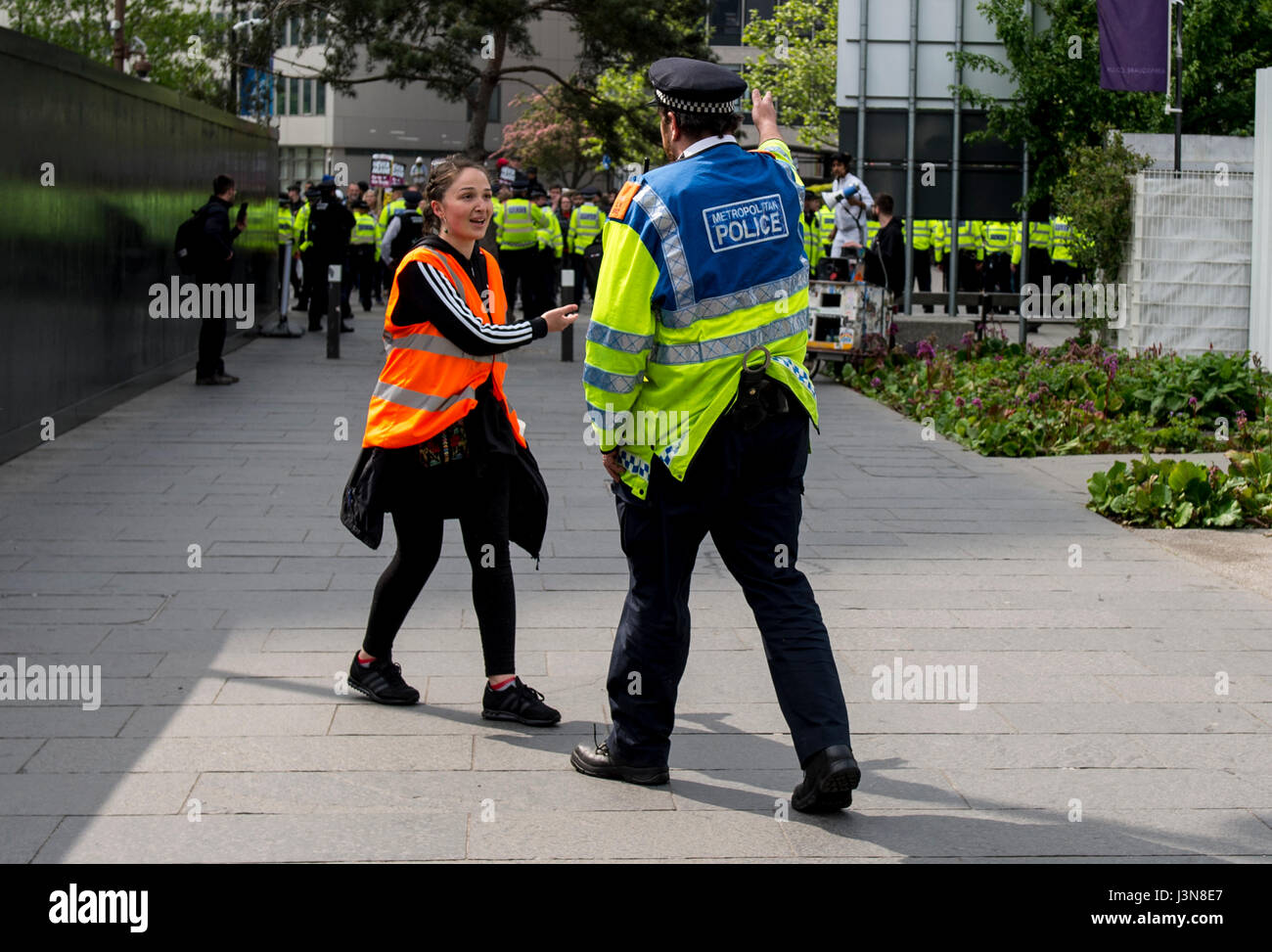 A police officer warns a legal observer as two groups of protesters ...