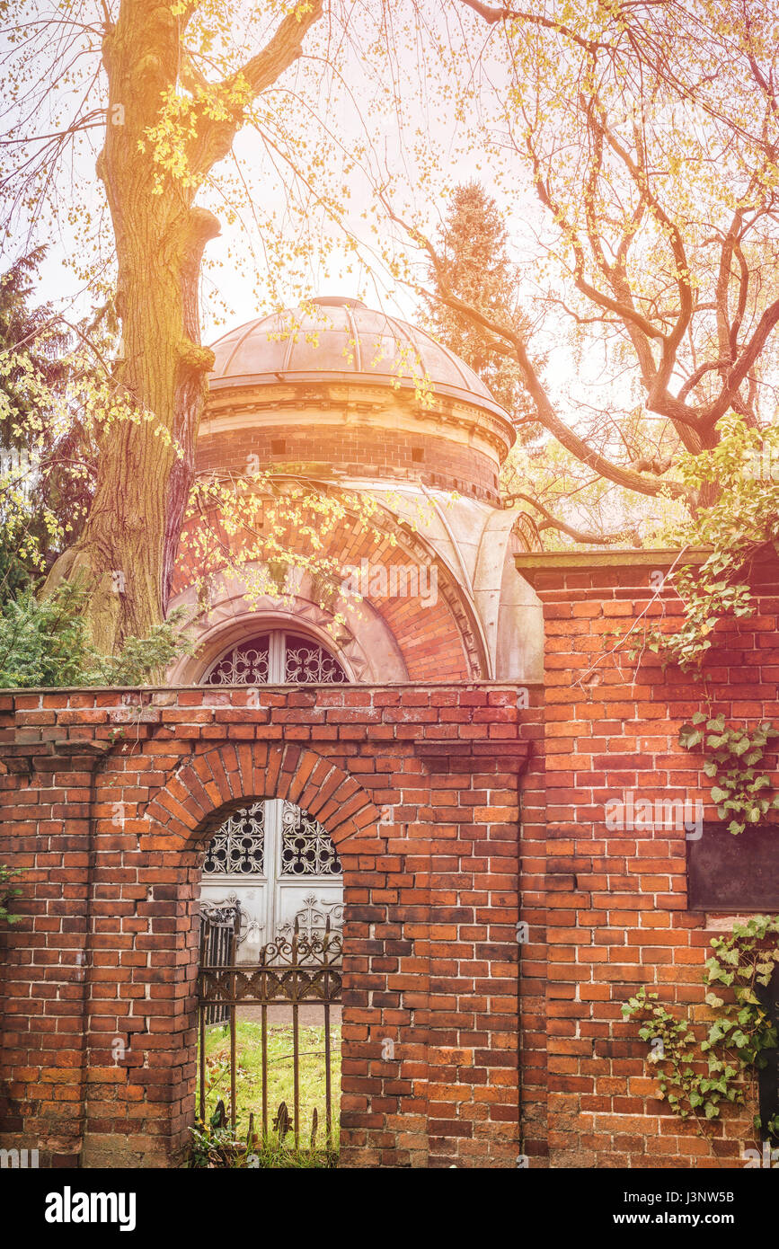red brick wall with gate, in front of an old tomb Stock Photo - Alamy