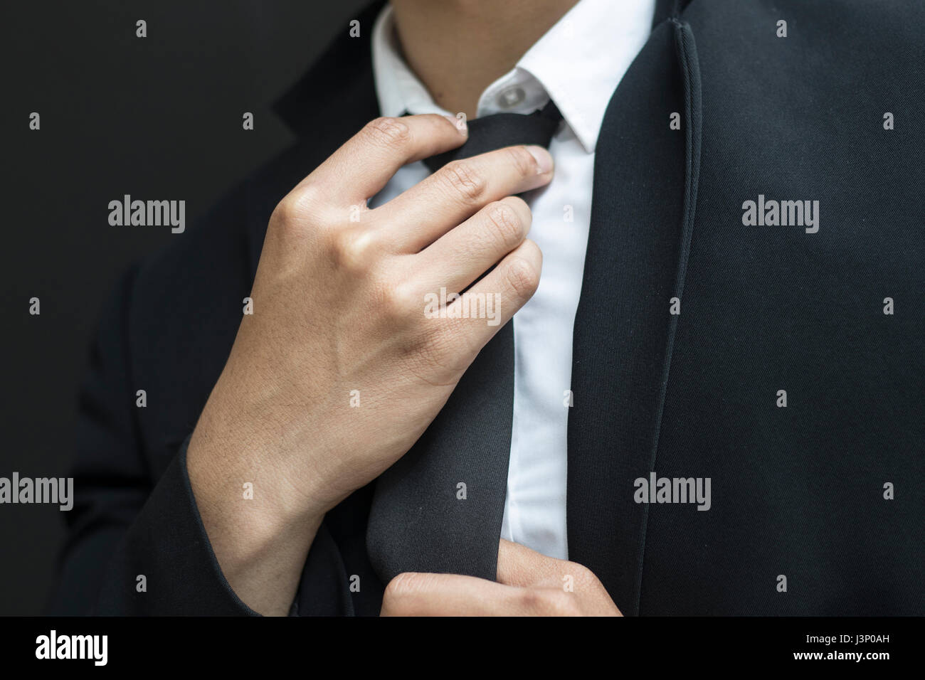 young business man adjusting his neck tie Stock Photo - Alamy