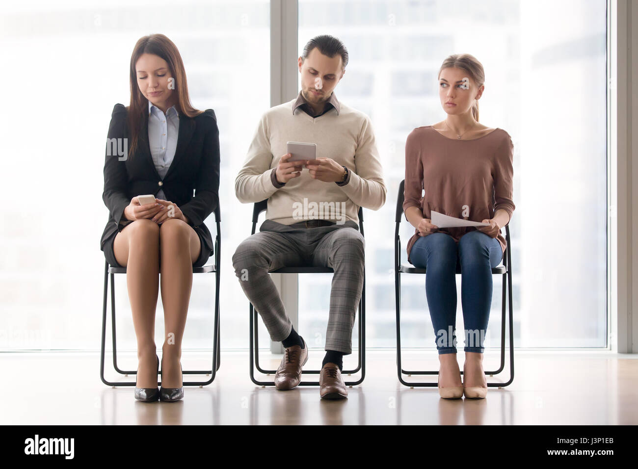 Bored people sitting on chairs waiting for a long time Stock Photo - Alamy