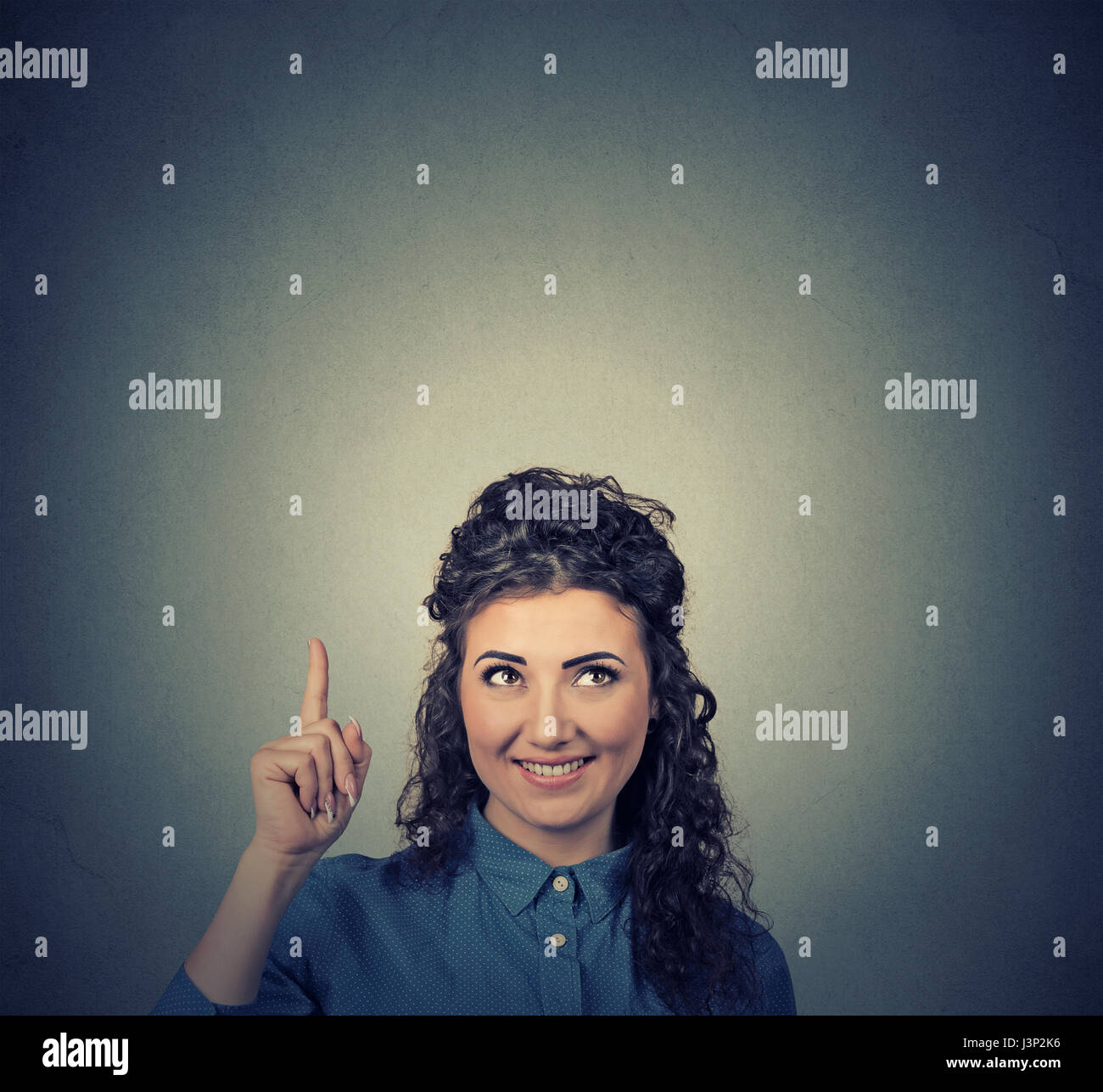Portrait happy beautiful woman thinking looking up pointing finger at ...