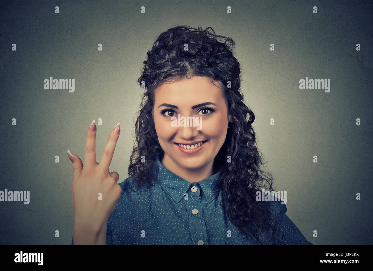 Closeup portrait of young pretty woman giving a three fingers sign ...