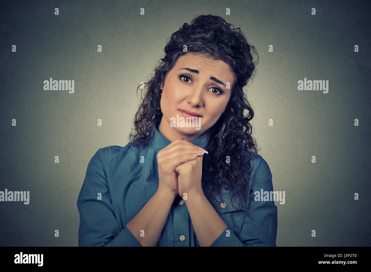 Closeup portrait young woman gesturing with clasped hands, please ...