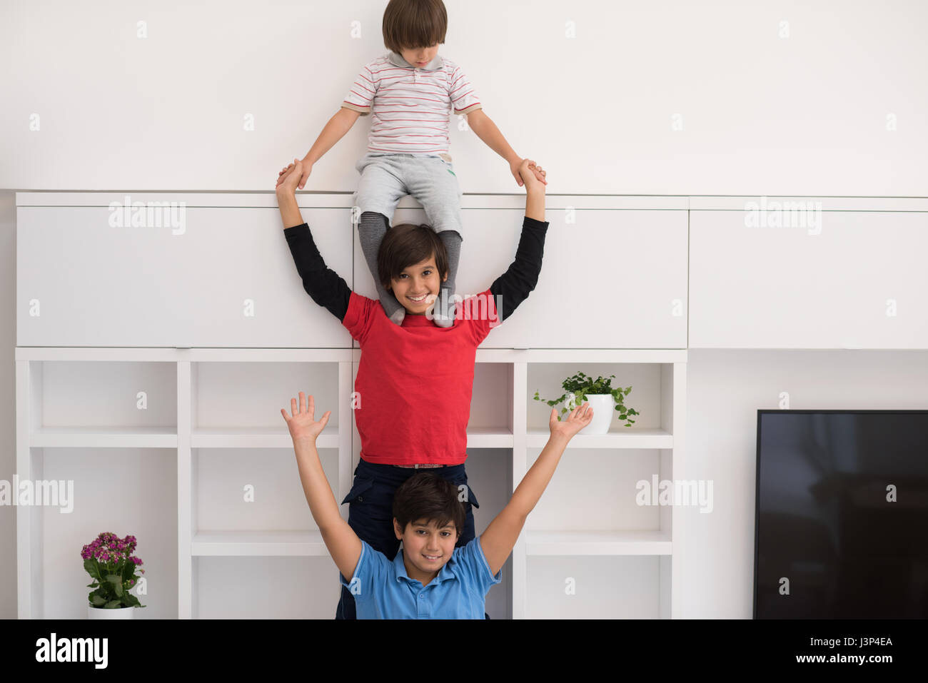 happy young boys having fun and posing line up piggyback in new modern ...